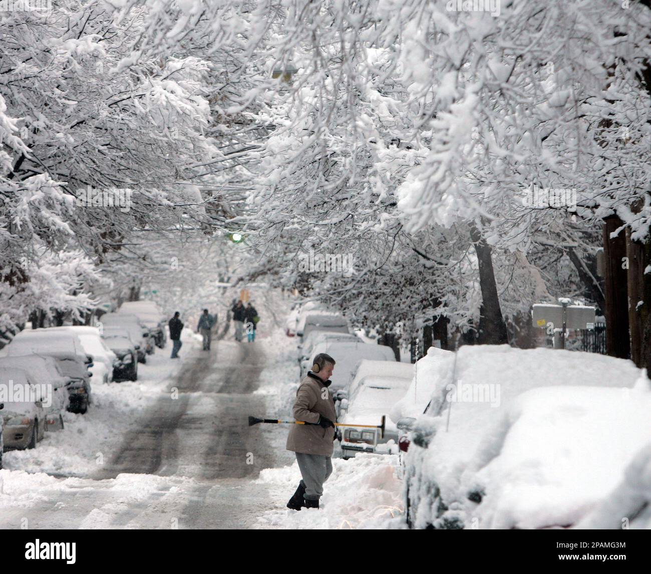 Tina Connell clears snow from her car in Albany, N.Y., Monday, Dec. 31 ...