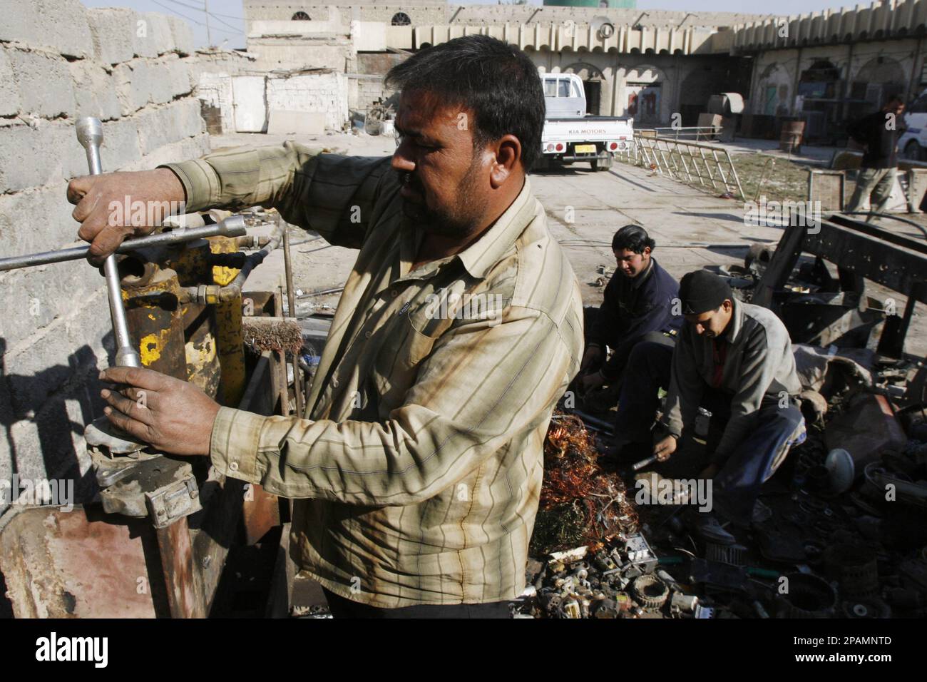 Auto mechanic Allawi Karim Muhsin, left, works in his shop in the Kasra ...