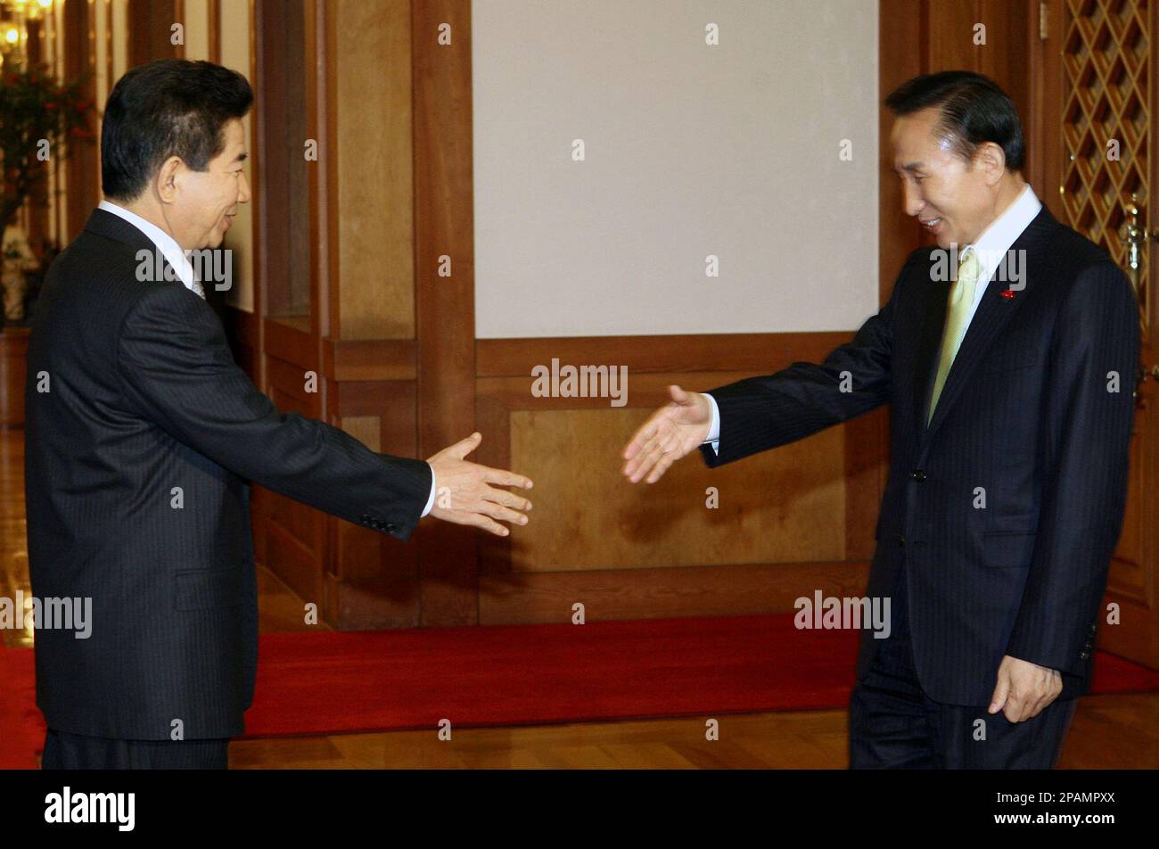 South Korean President Roh Moo-hyun, left, meets with the country's President-elect Lee Myung ...