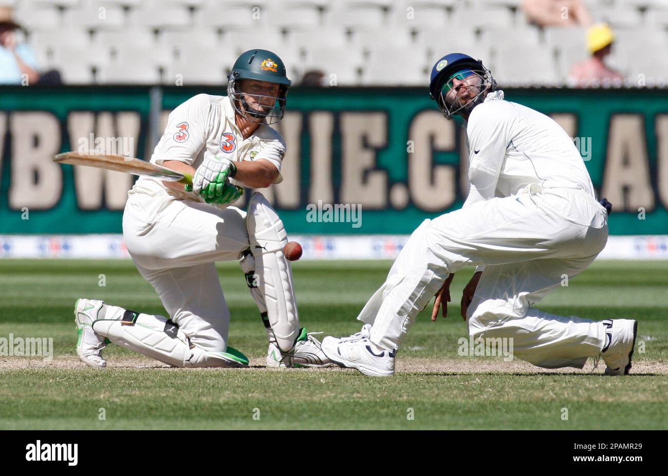 Australia's Adam Gilchrist, left, hits a boundary as India's VVS Laxman ...