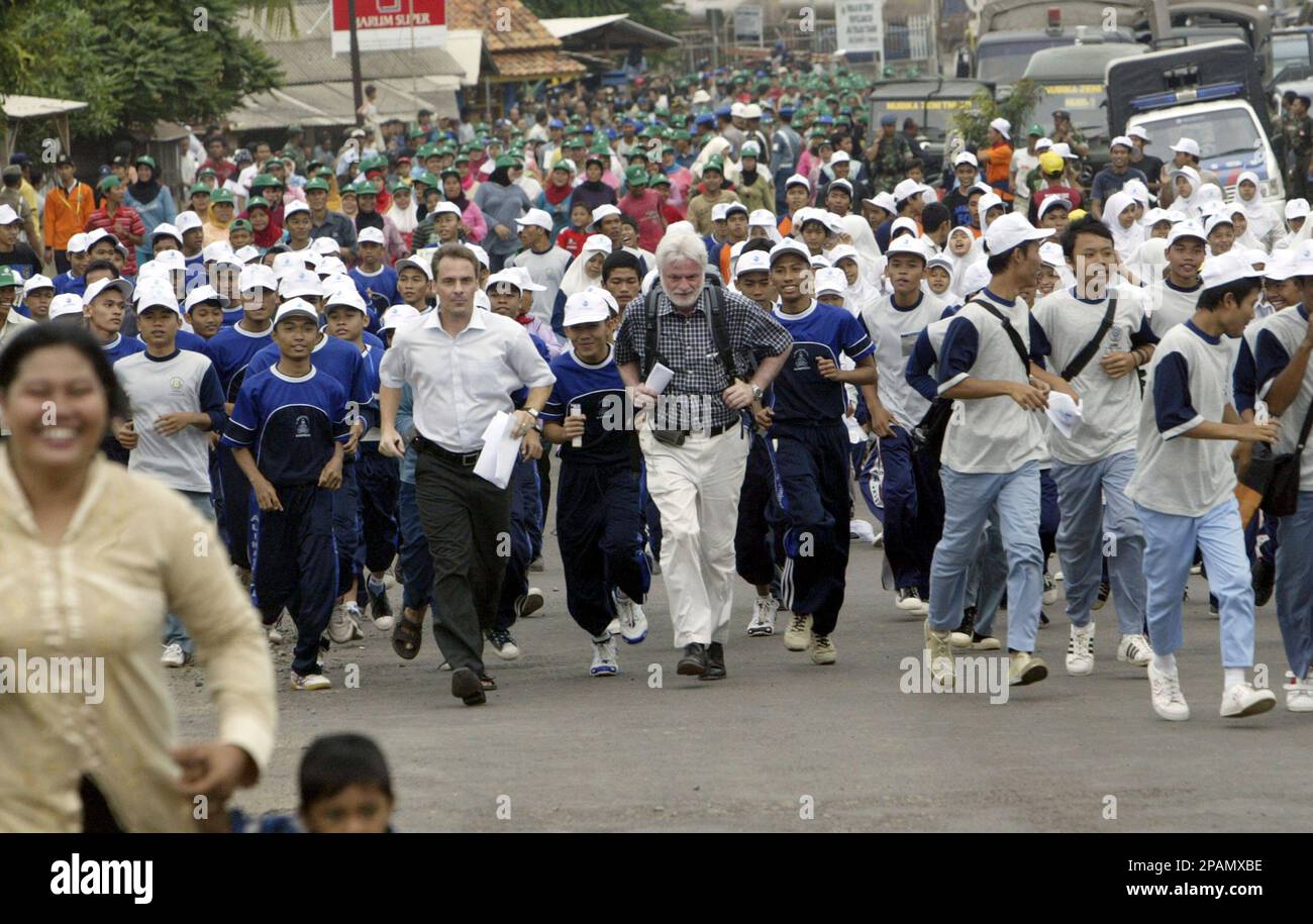 Participants run toward higher ground during a tsunami drill in Cilegon ...