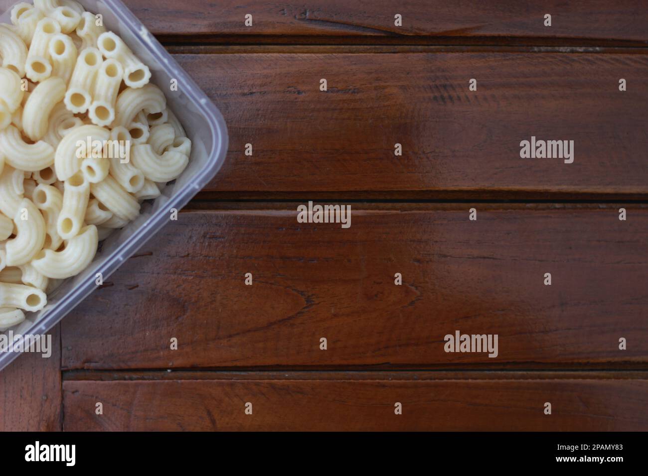 a close up of boiled macaroni in a transparent container on natural ...