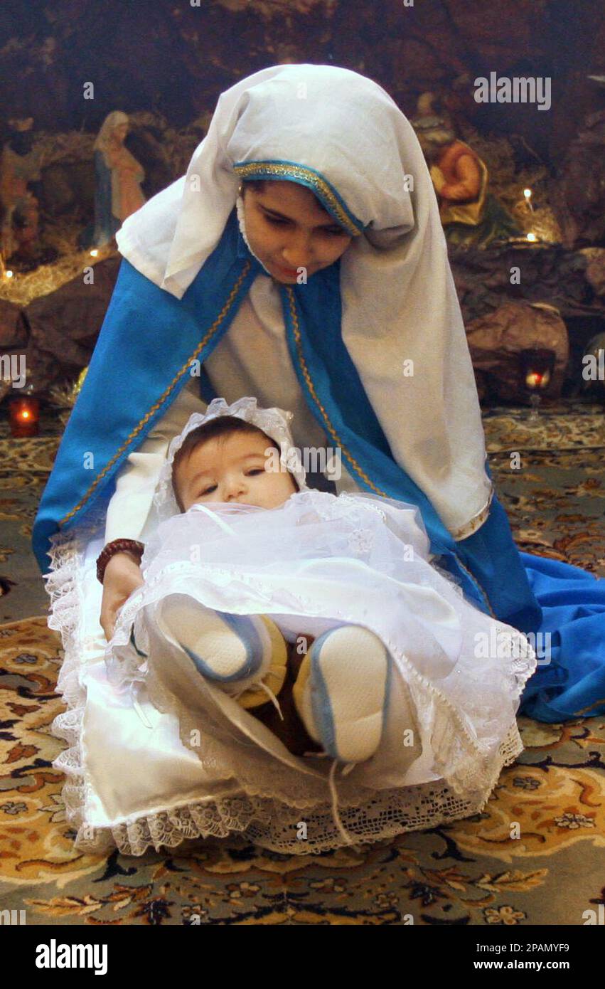 An Iraqi girl and an infant take part in a play reenacting the birth of ...