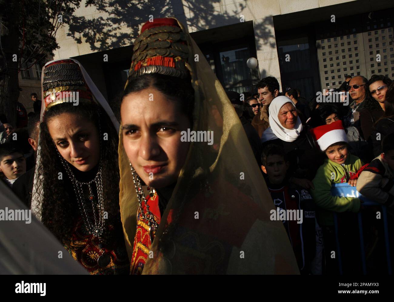 Palestinian Christians, some wearing traditional costume, gather during ...