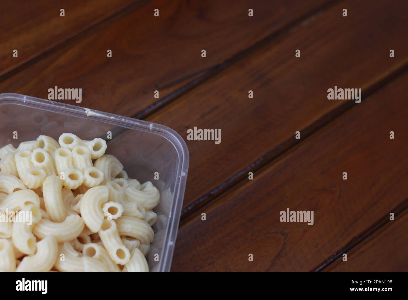 a close up of boiled macaroni in a transparent container on natural ...