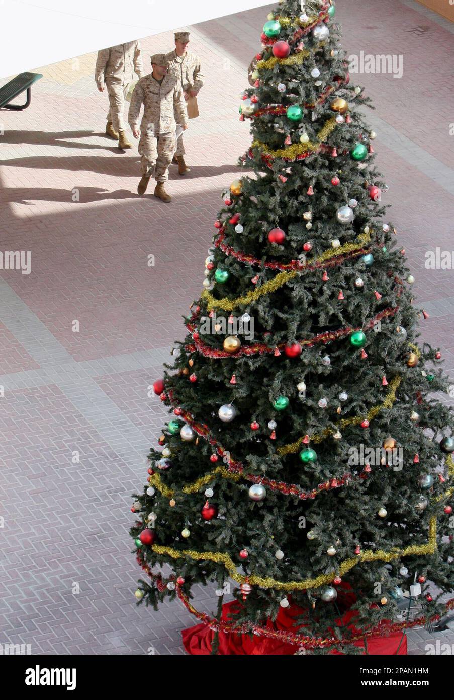 U.S. military personnel walk by a giant Christmas tree Sunday, Dec. 23 ...