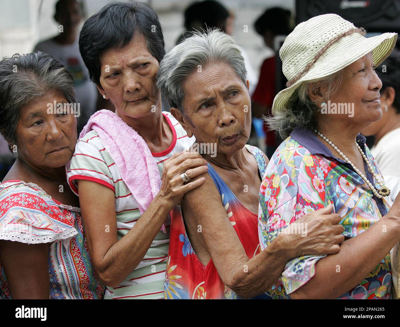Elderly Filipino women wait in line during a Christmas gift giving ...