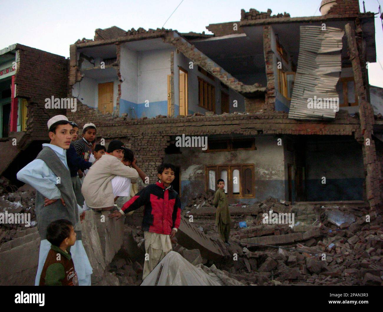 Local children sit before the house of Commander Rahim Shah, deputy to ...