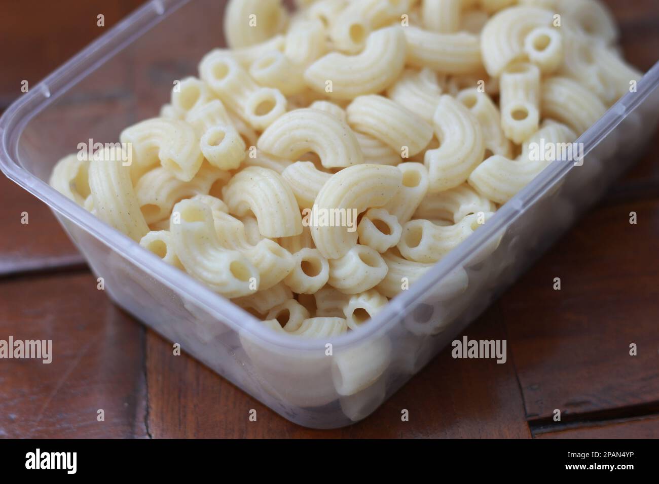 a close up of boiled macaroni in a transparent container on natural ...