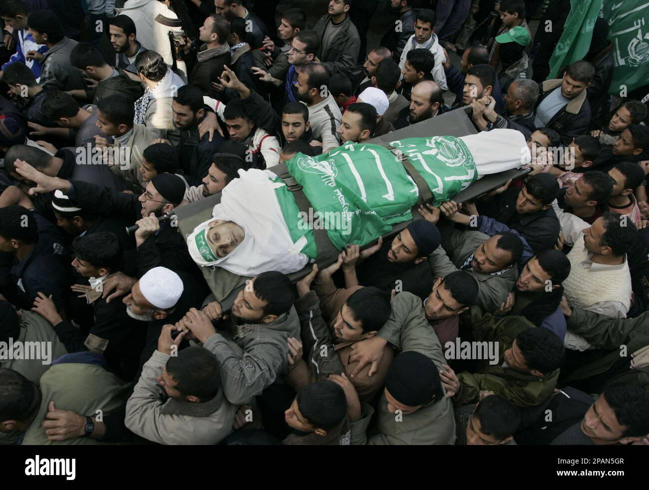 Palestinian mourners carry the body of a Hamas militant during his ...
