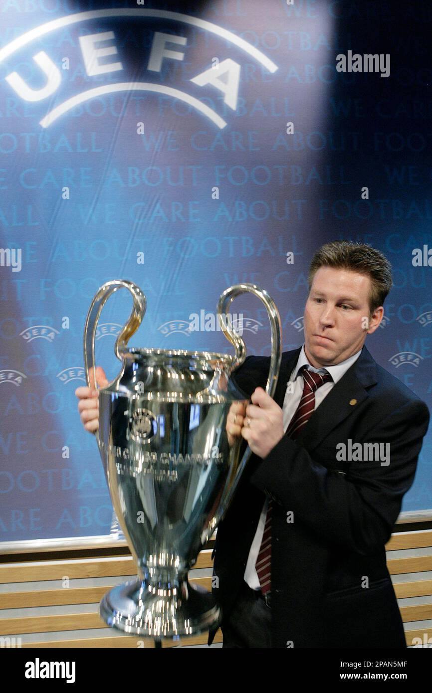An UEFA staff member takes off the Champions League trophy after the ...