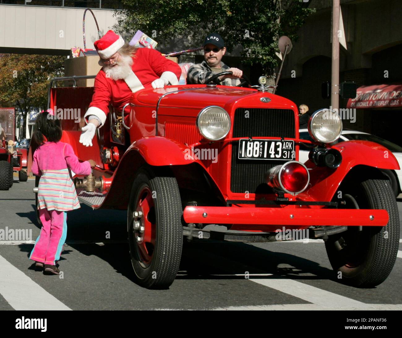 Serenity Erwin, 4, left, runs to greet a man dressed as Santa Claus ...