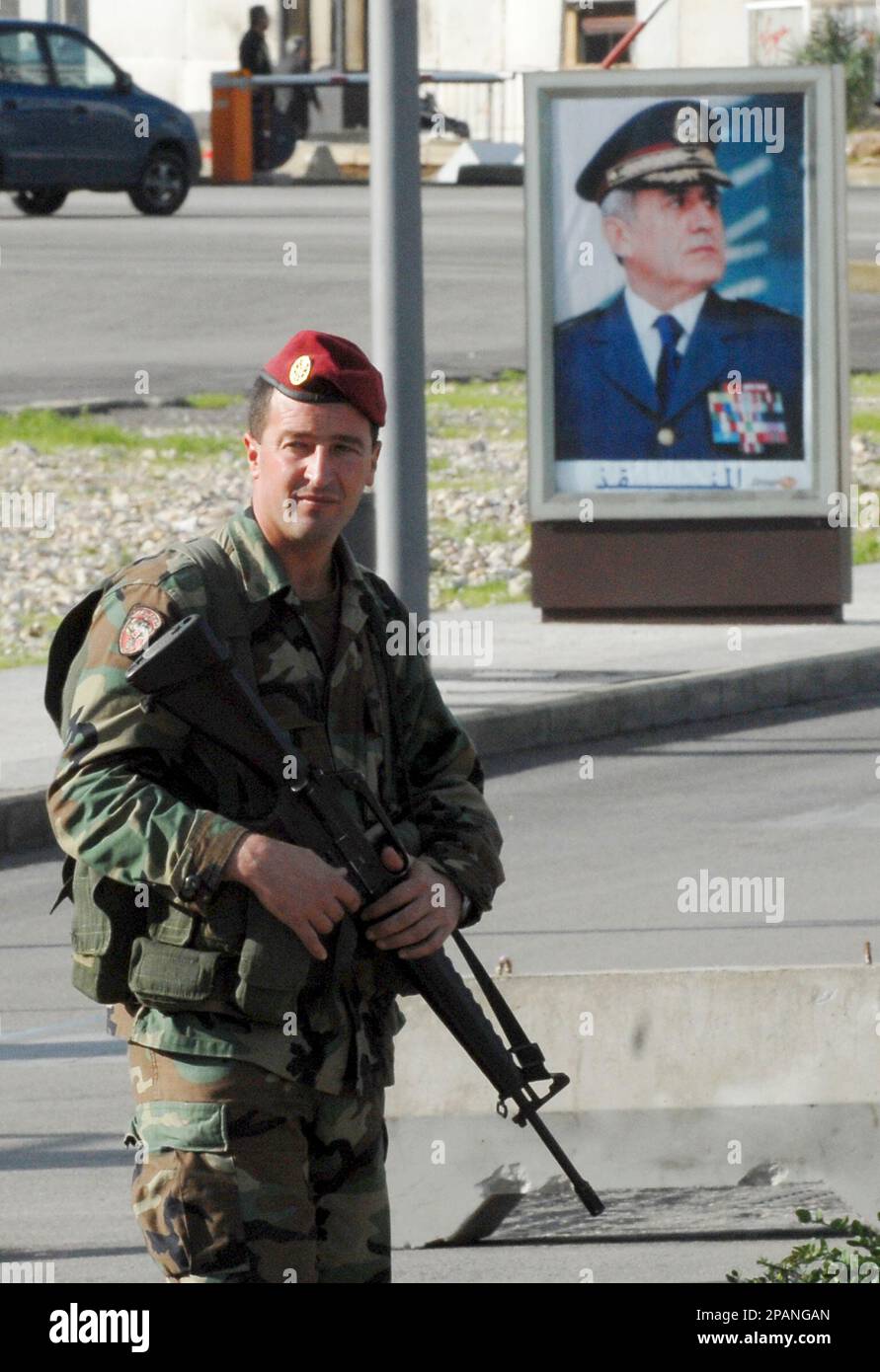 A Lebanese soldier stands guard in front of a picture of Army Commander ...
