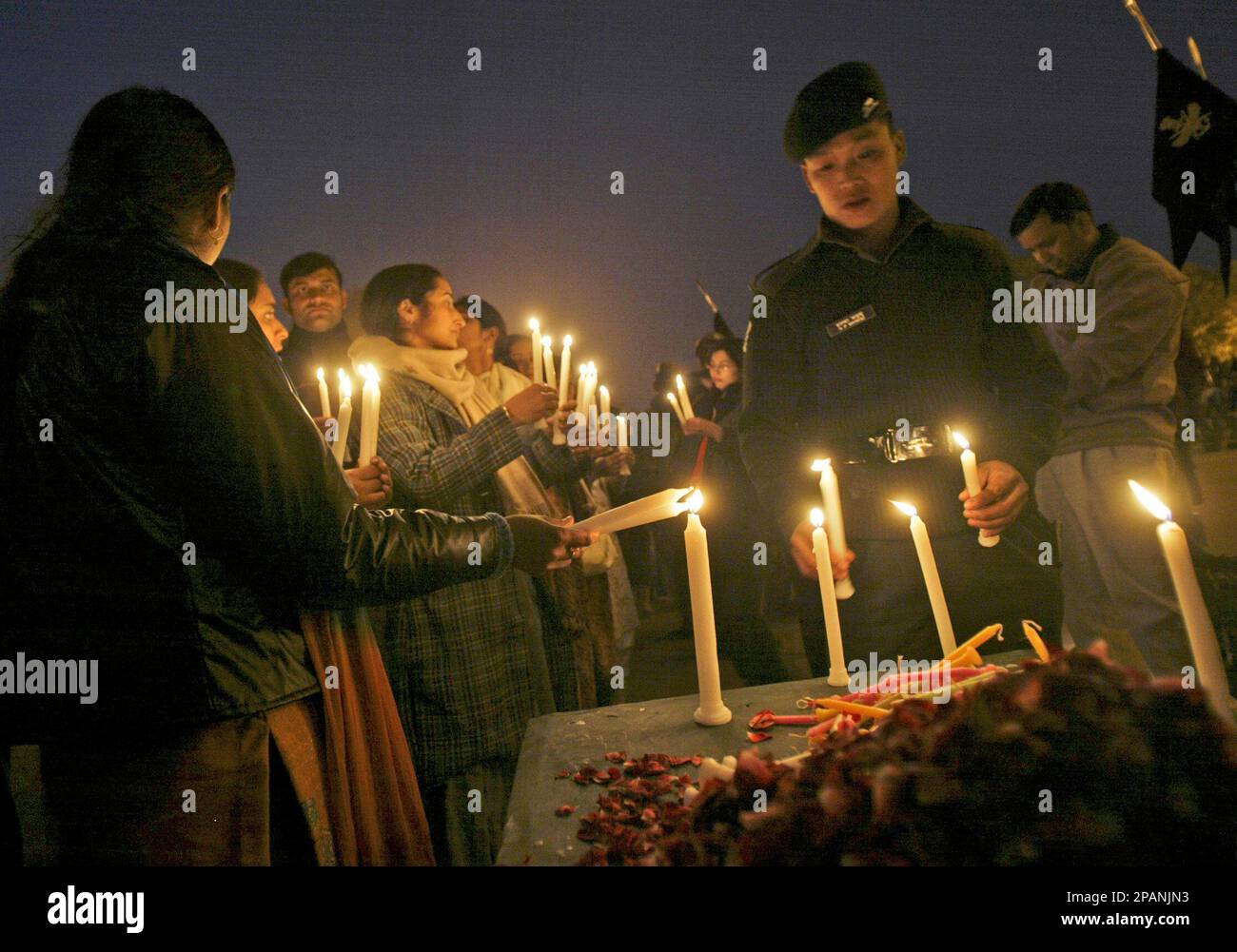 Indian Army soldier, right, and members of the public light candles in ...