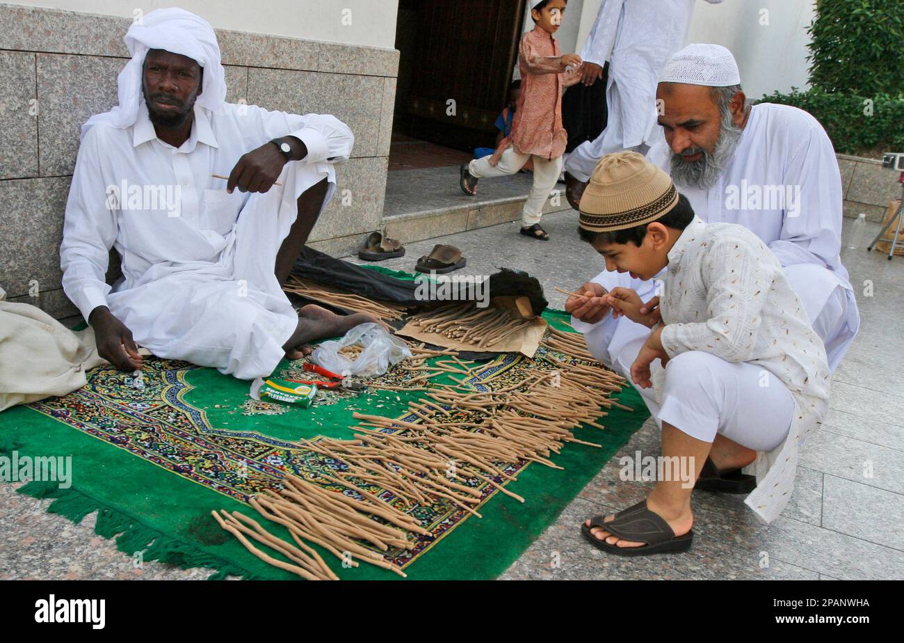A Muslim vendor, left, sells a traditional toothbrush called a "Misswak ...