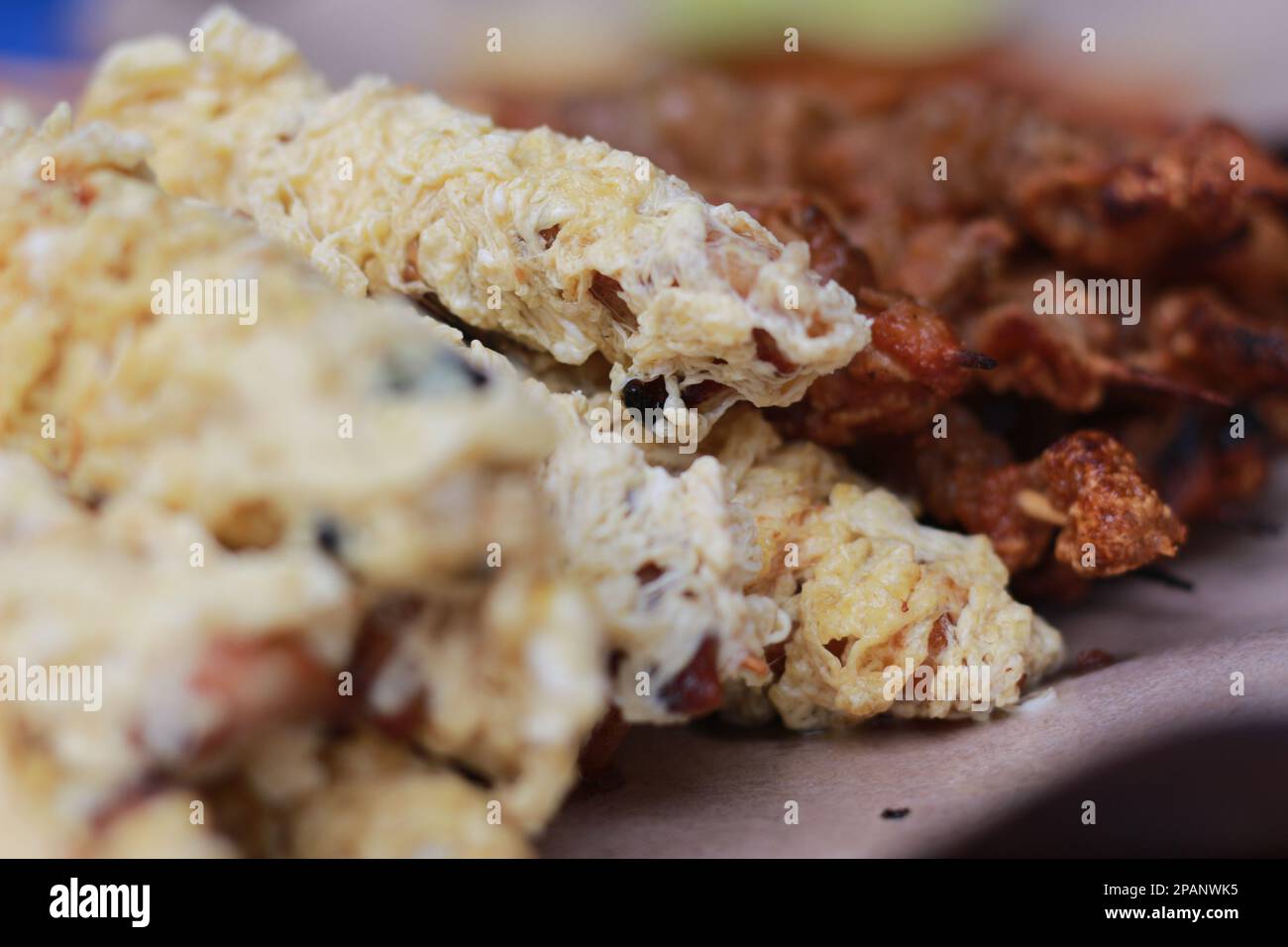 photo of chicken satay coated with fried egg and chicken intestine ...