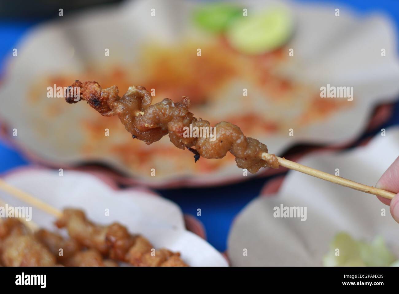 photo of chicken intestine satay and served with red chili sauce ...
