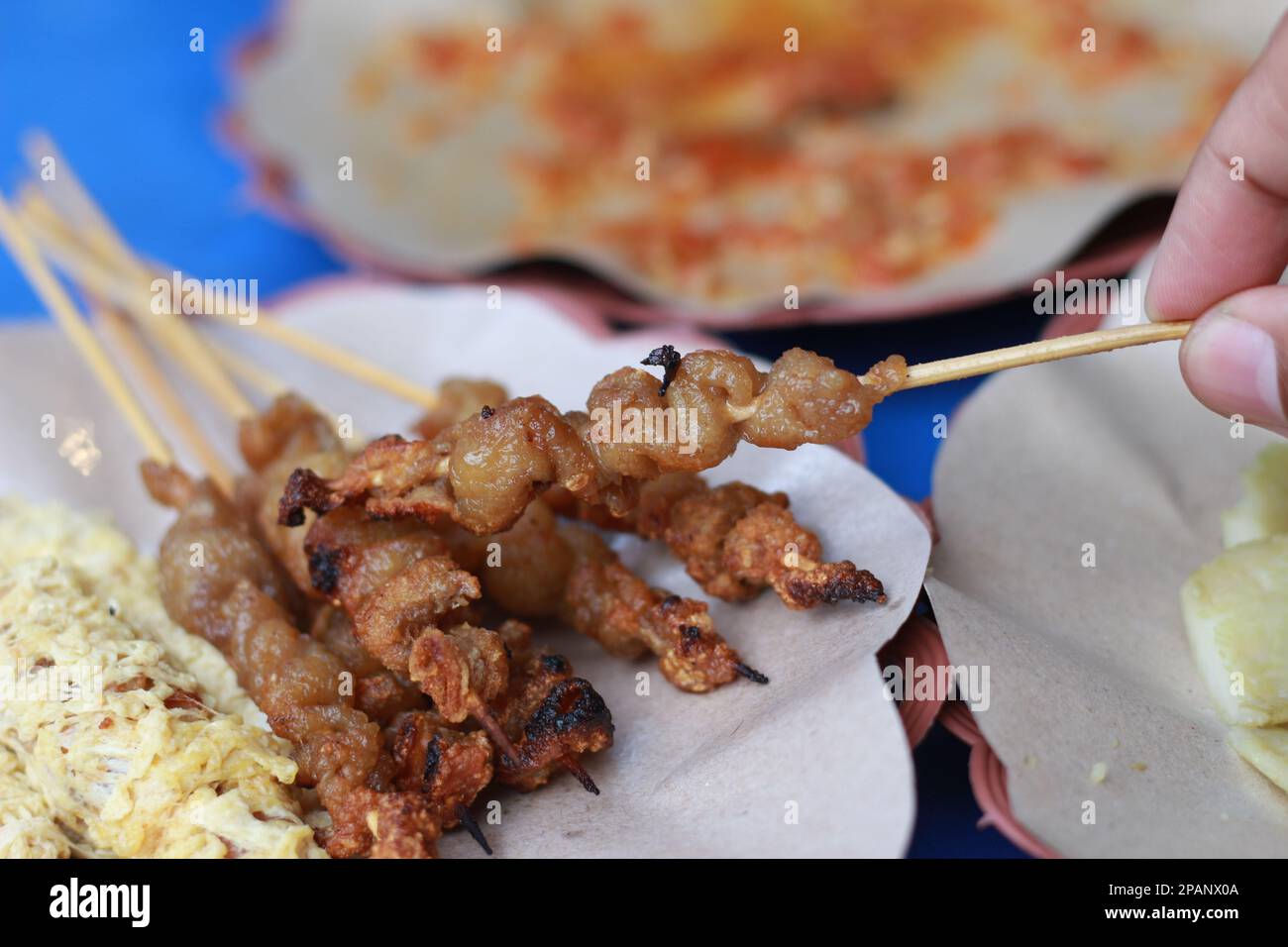 photo of chicken intestine satay and served with red chili sauce ...