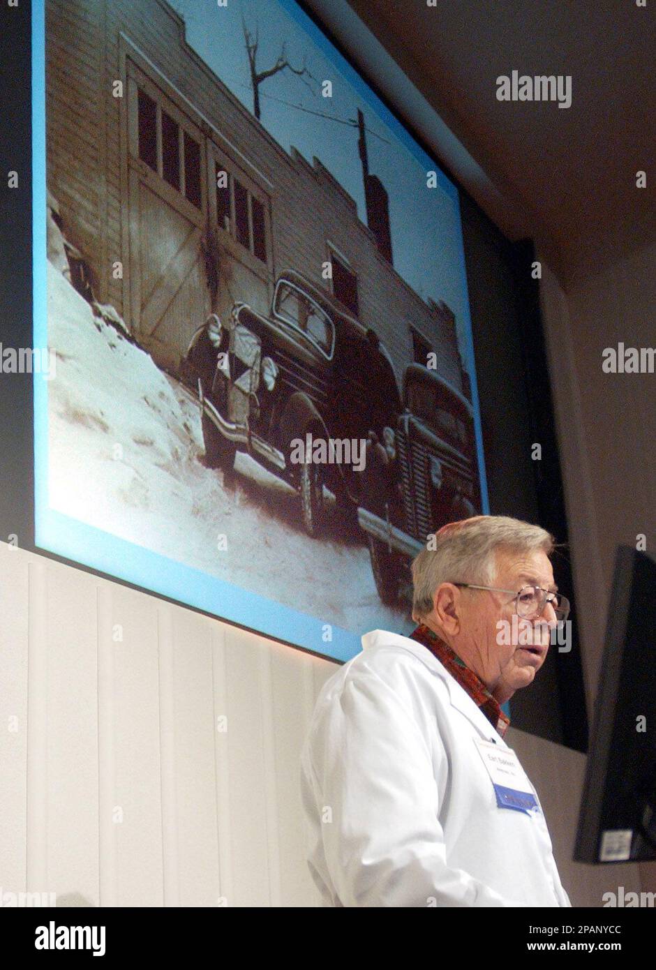 Standing before a photo of the late-1940s-era garage in which he ...
