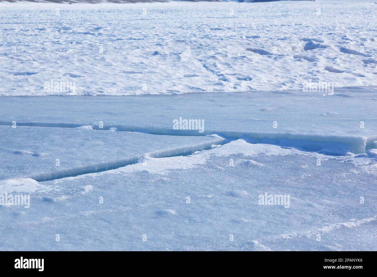Winter ice landscape. Cracks in the ice field. Nanural winter ...