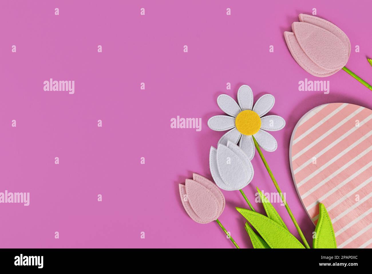 Felt tulip and daisy spring flowers and wooden Easter egg on purple ...