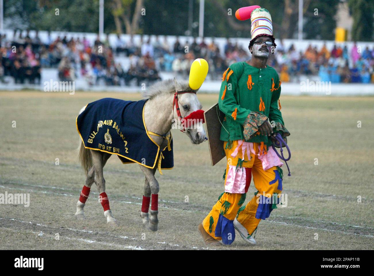 An Indian army soldier dressed as a joker entertains spectators during ...