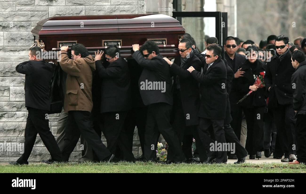 The casket of singer Sergio Gomez is carried to the burial site at West ...