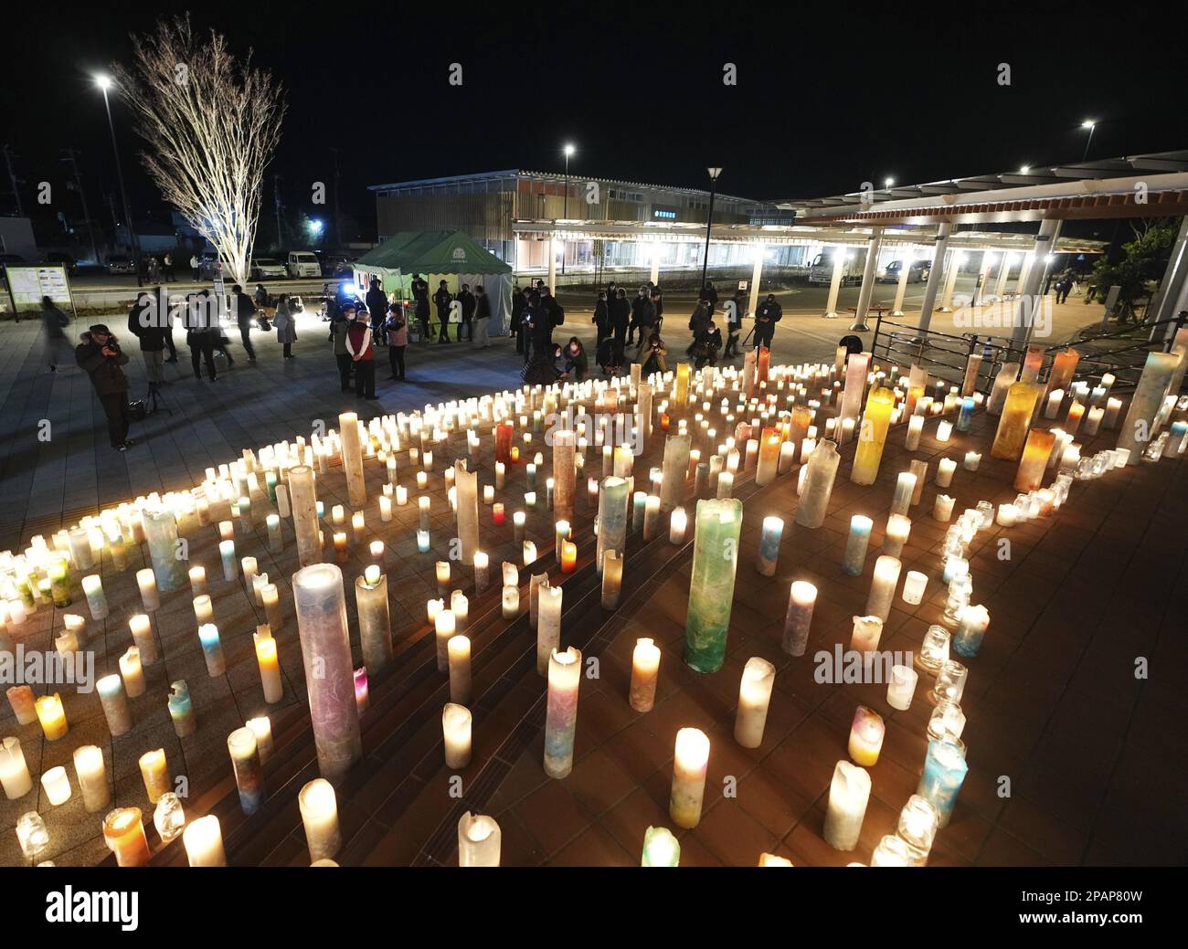 People hold a candlelight vigil in the Fukushima Prefecture town of ...