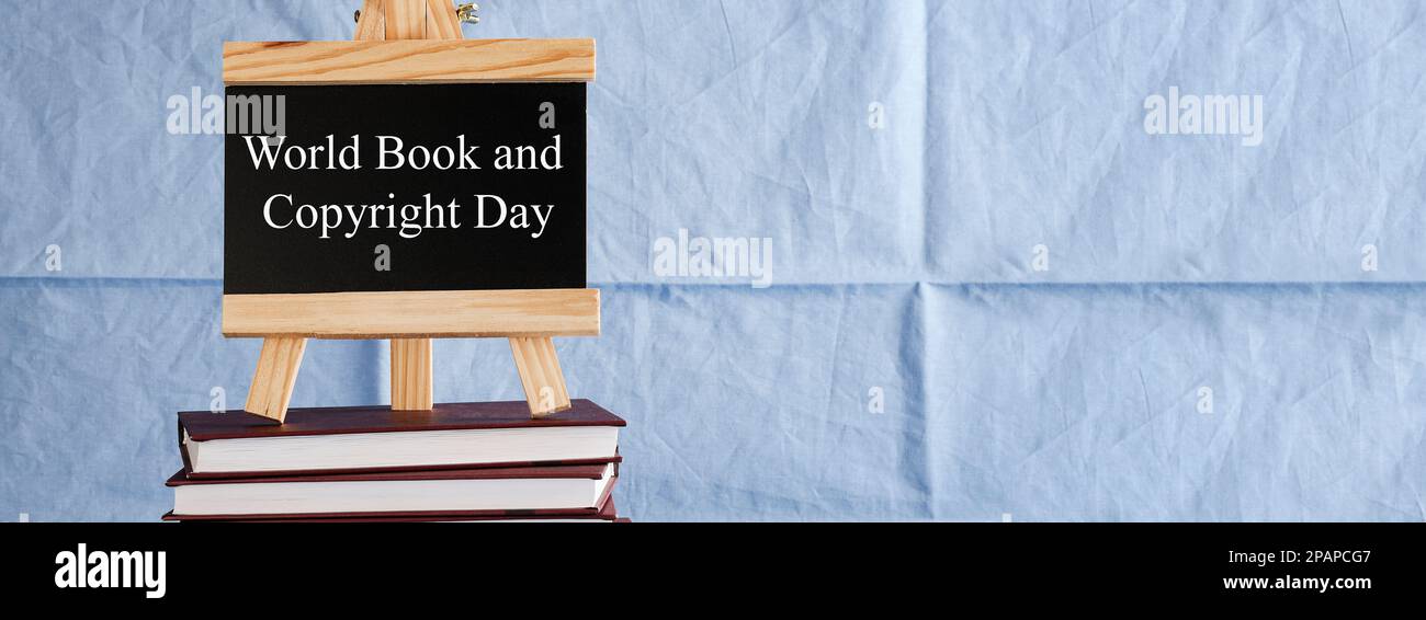 World Book and Copyright Day written on black board on stack of books ...