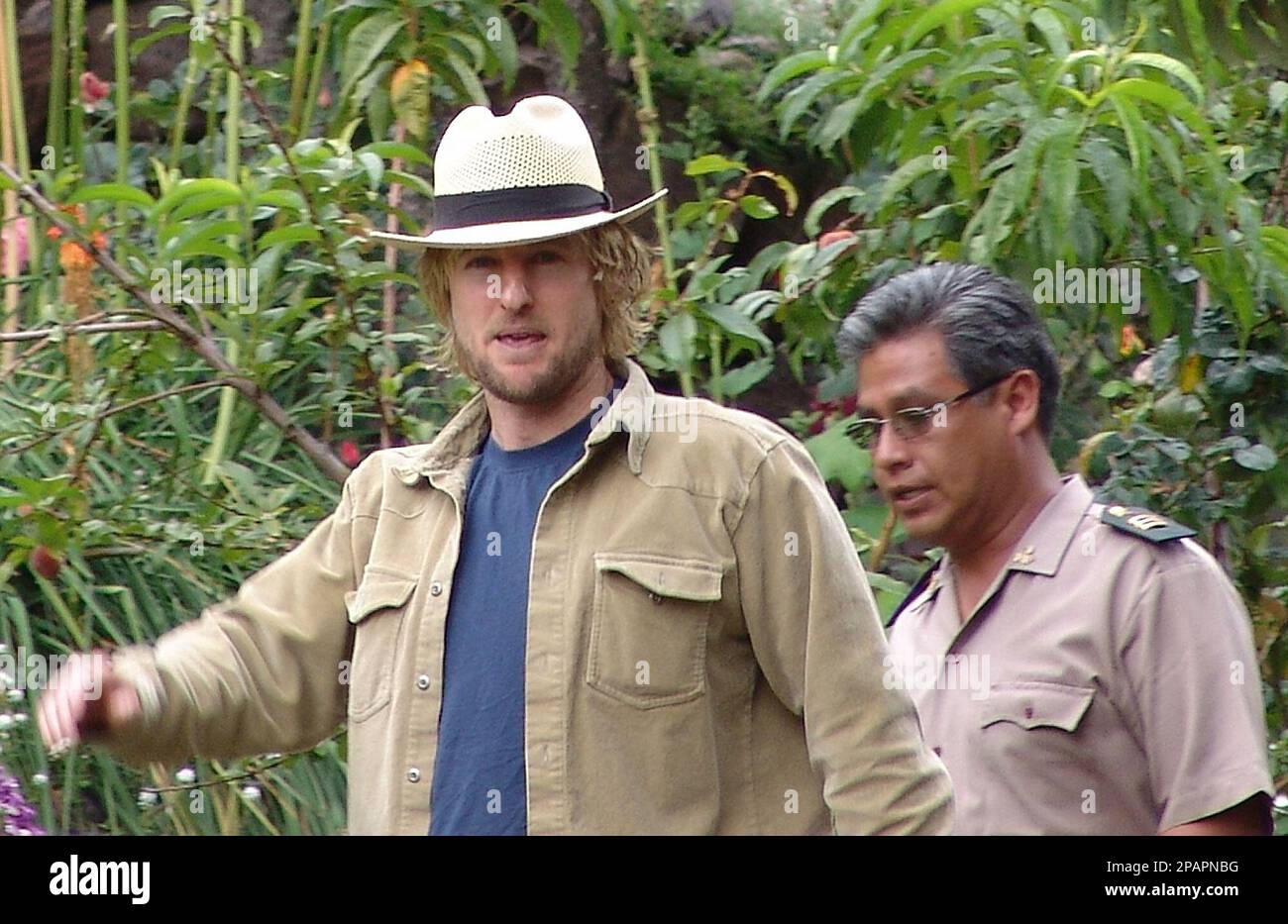 U.S. actor Owen Wilson, left, walks with a police officer as he visits ...