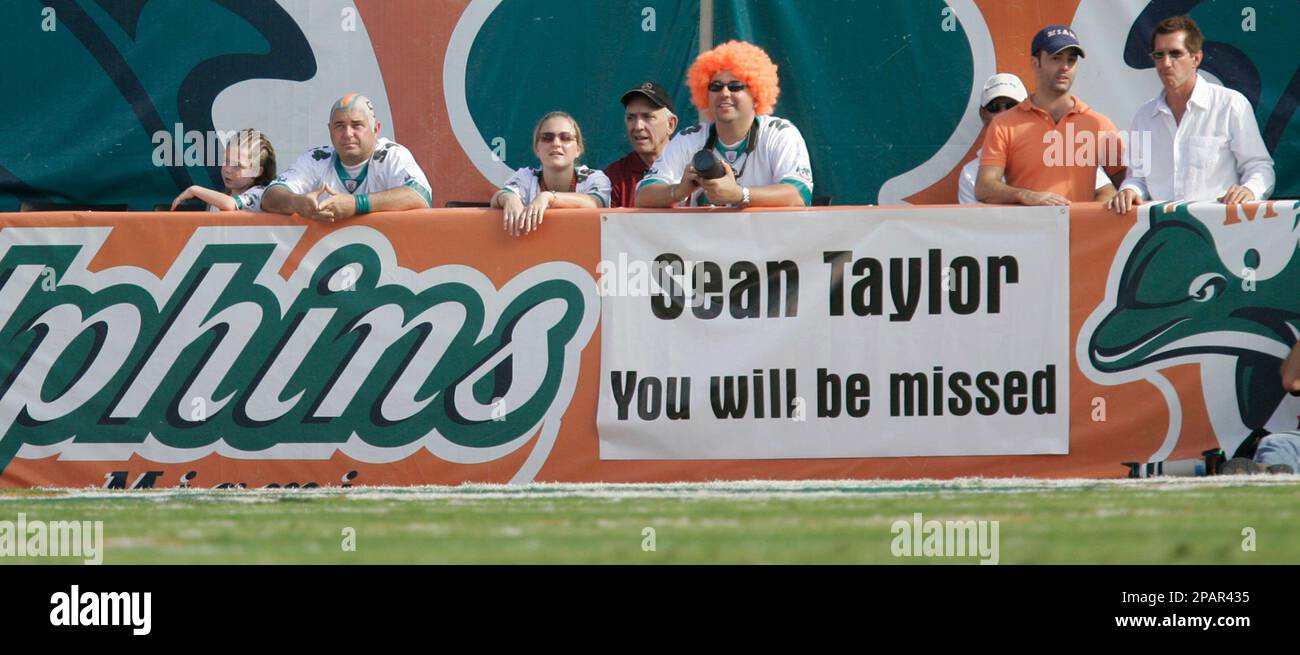 Miami Dolphins fans stand behind a banner honoring slain Washington ...