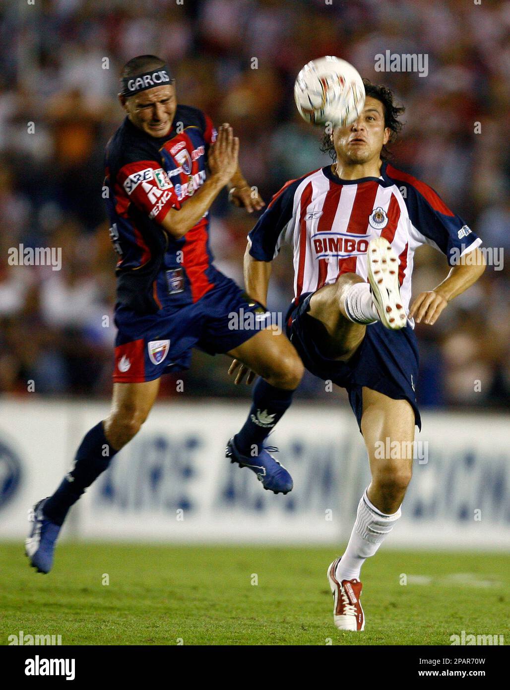 Chivas' Hector Reynoso, right, fights for the ball with Atlante's Jose ...