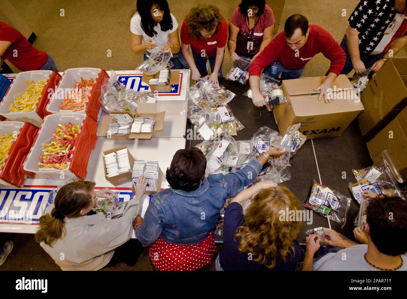 Michael McDow, top right, tapes a care package of snacks and personal ...