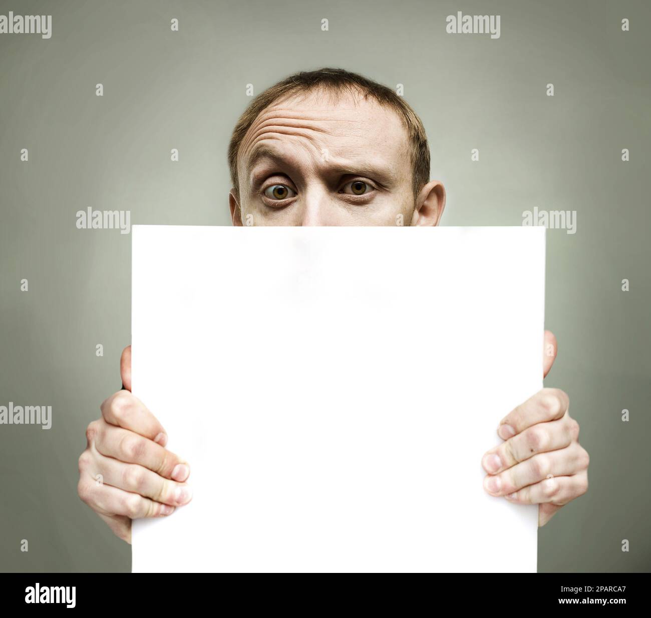 Young man holding blank sign paper Stock Photo - Alamy