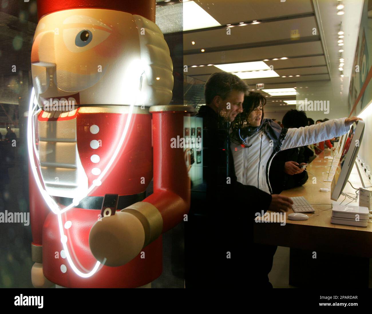 A display nutcracker soldier sports an iPod as shoppers examine ...