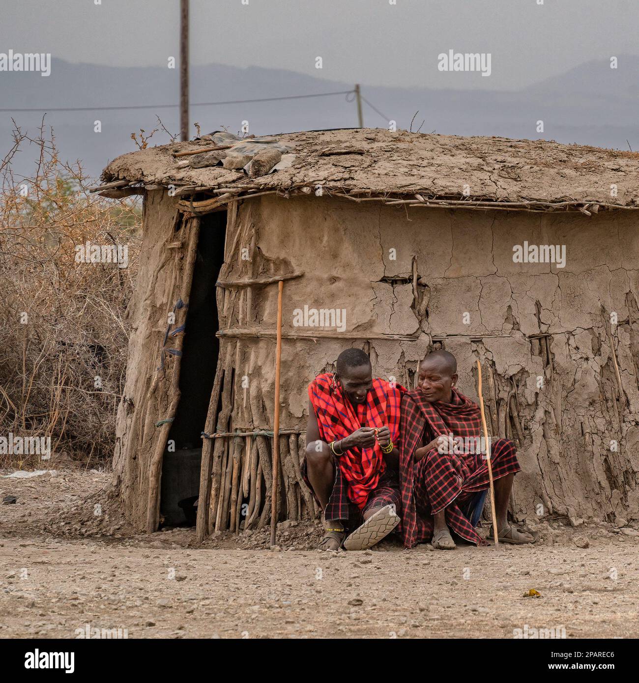 Karatu, Tanzania - October 16th, 2022: Two masai men sitting by a hut ...