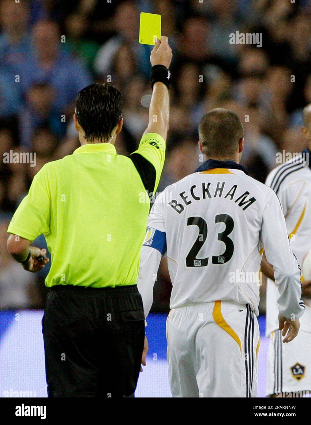 Referee Mark Shield left, shows England's LA Galaxy soccer star David ...