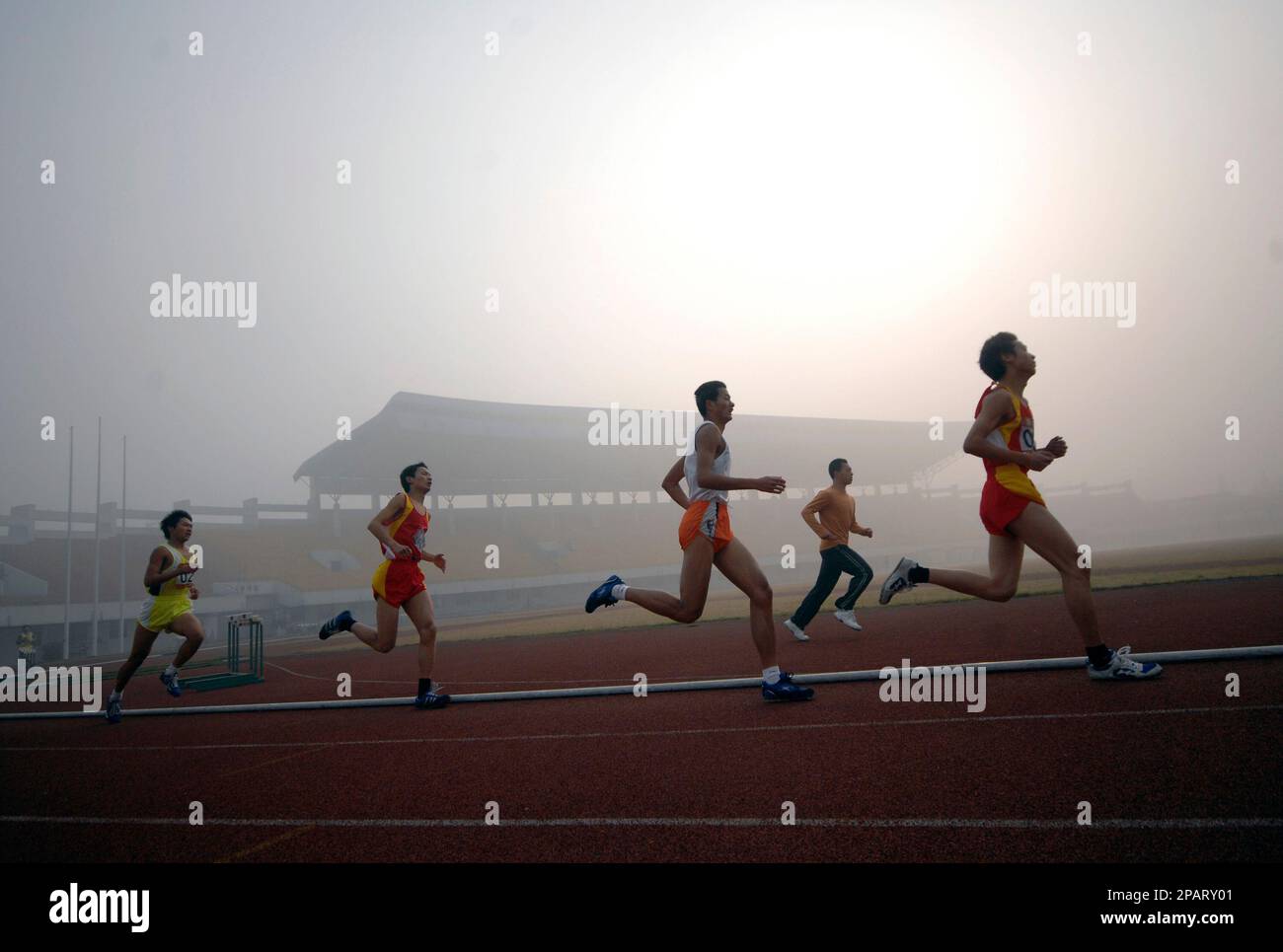 Chinese athletes train on the track under a hazy sky at a sports school ...