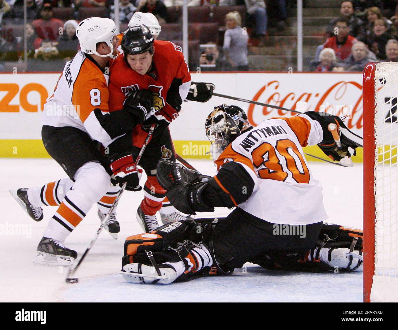 Ottawa Senators' Chris Neil , center, fights for a shot on Philadelphia ...