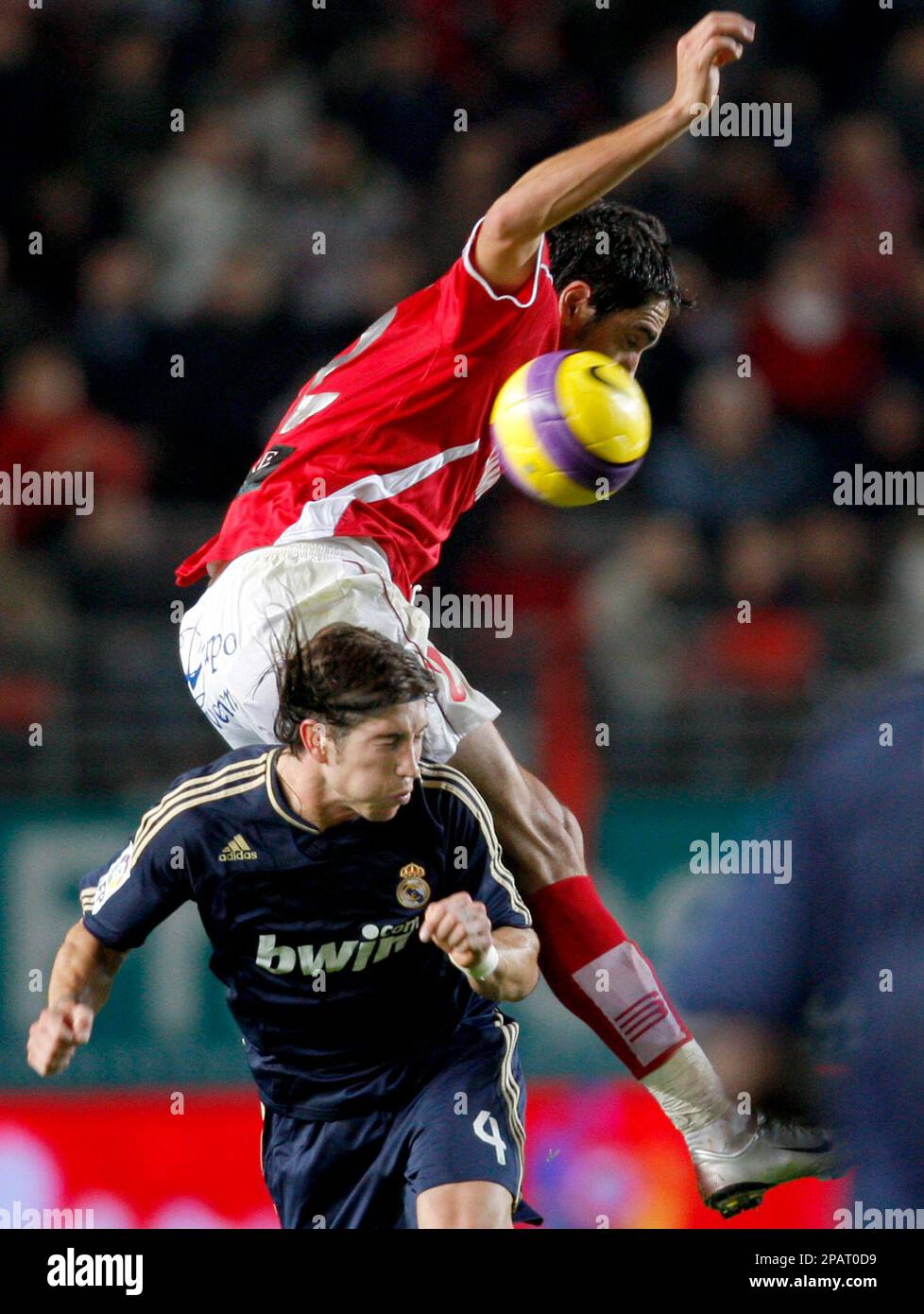 Real Madrid player Sergio Ramos, bottom, jumps for a high ball with ...