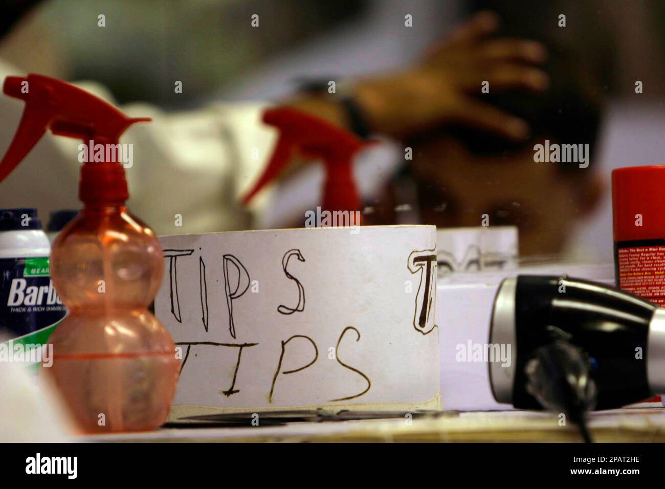 An Afghan barber trims the hair of a US soldier of 82nd Airborne as the ...
