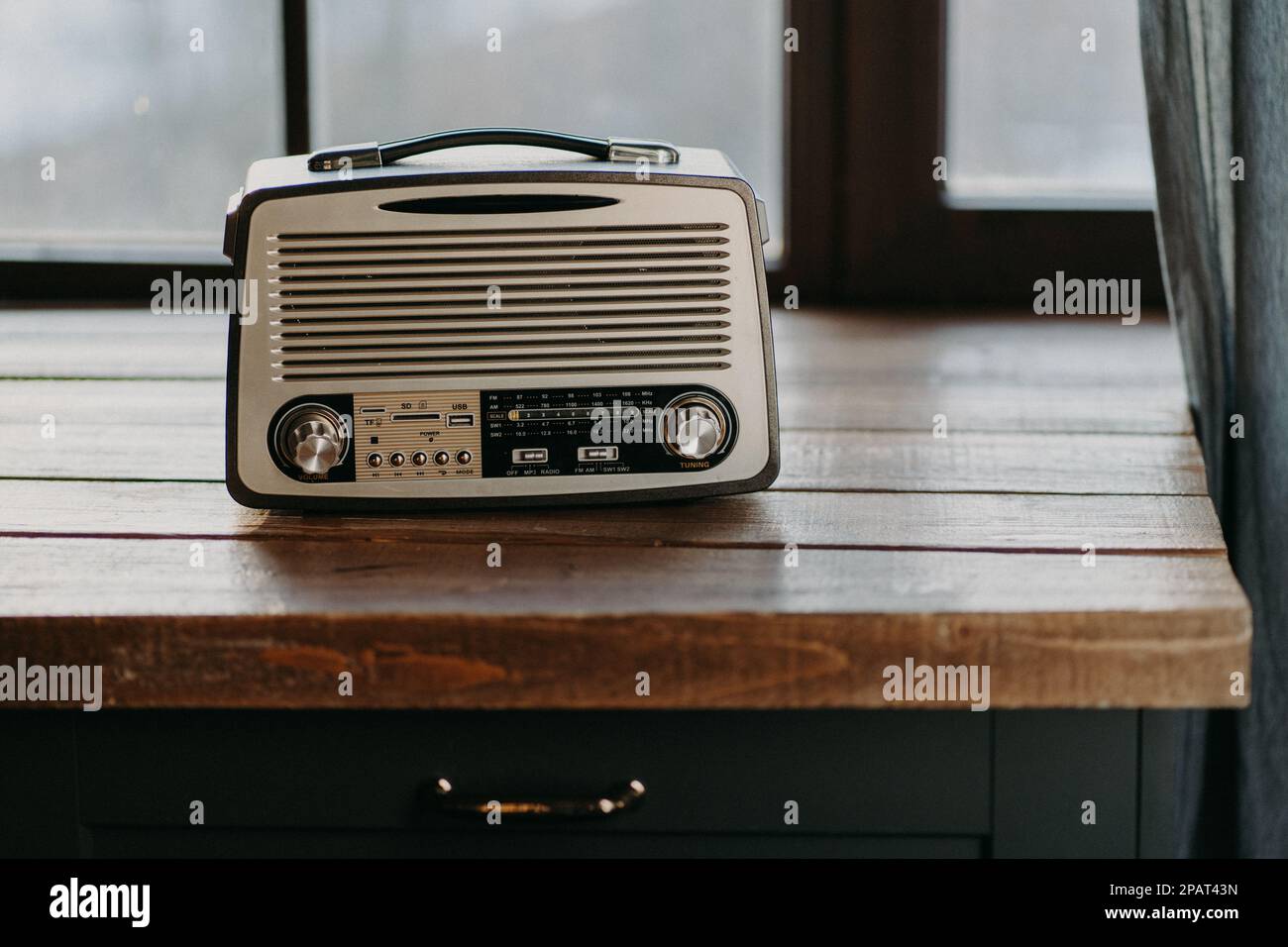 Retro vintage radio on wooden table surface near window. Back to 80s ...