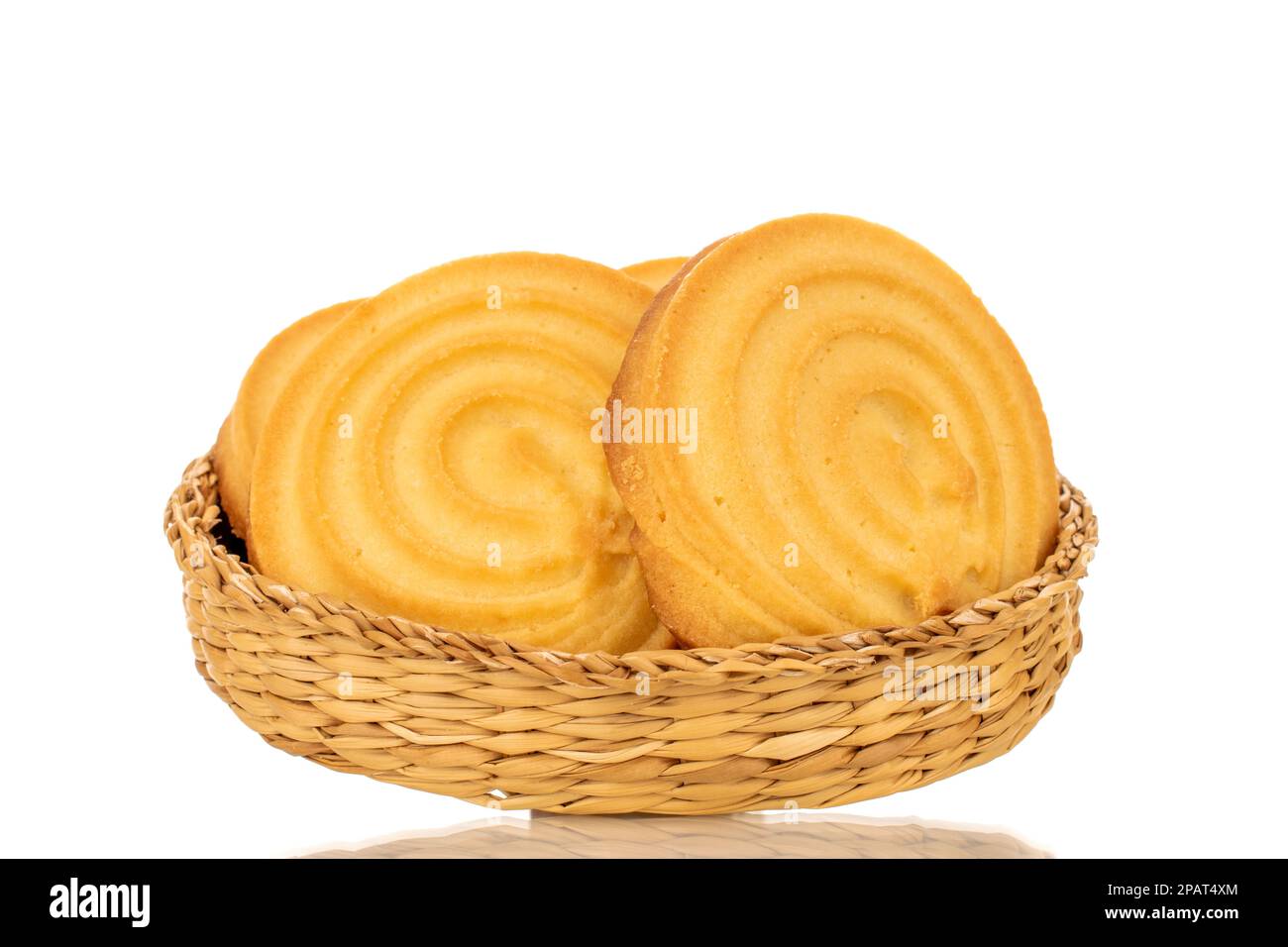 A few sweet cookies on a straw plate, macro, isolated on white ...