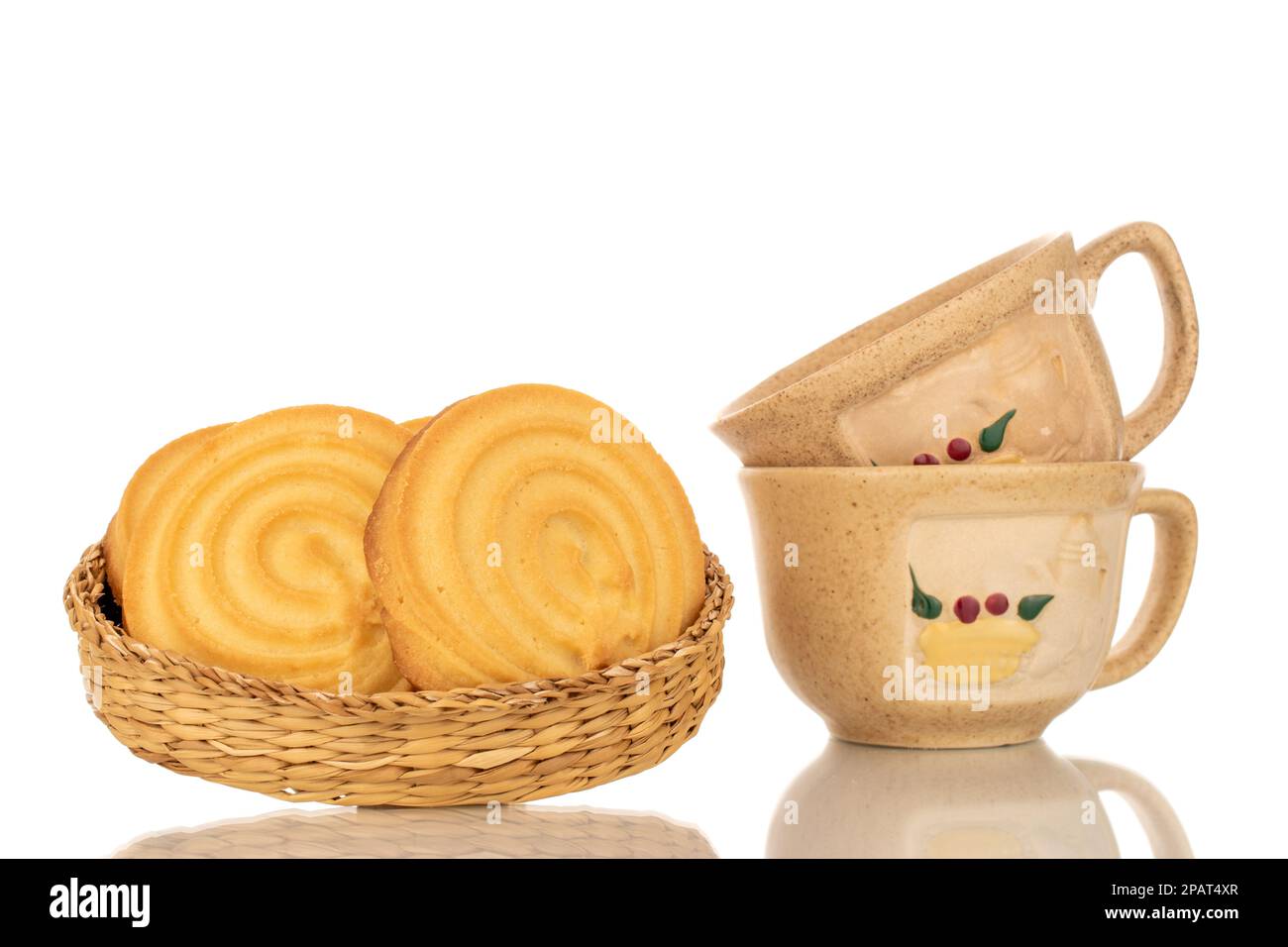 A few sweet cookies on a straw plate with two ceramic cups, macro ...