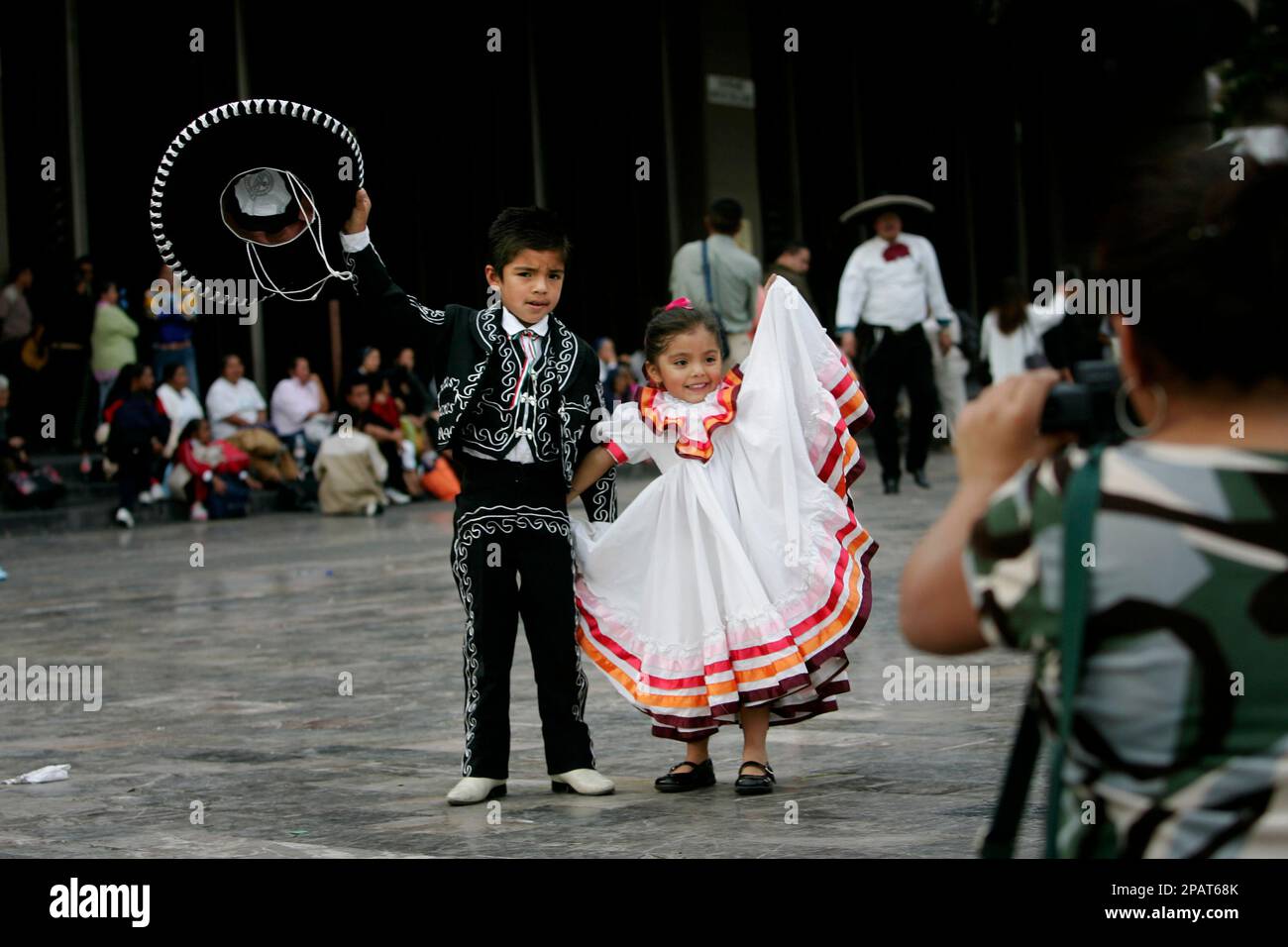 Children dressed in traditional Mexican clothes pose for a photograph ...