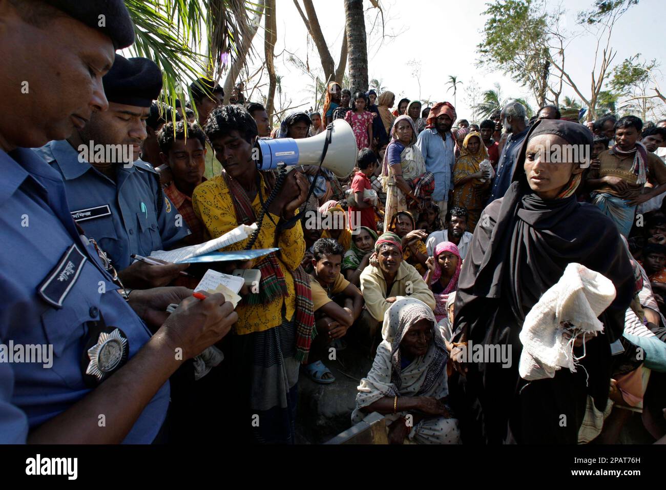 Policemen read out a list of cyclone affected villagers to receive relief materials at Gabtala ...