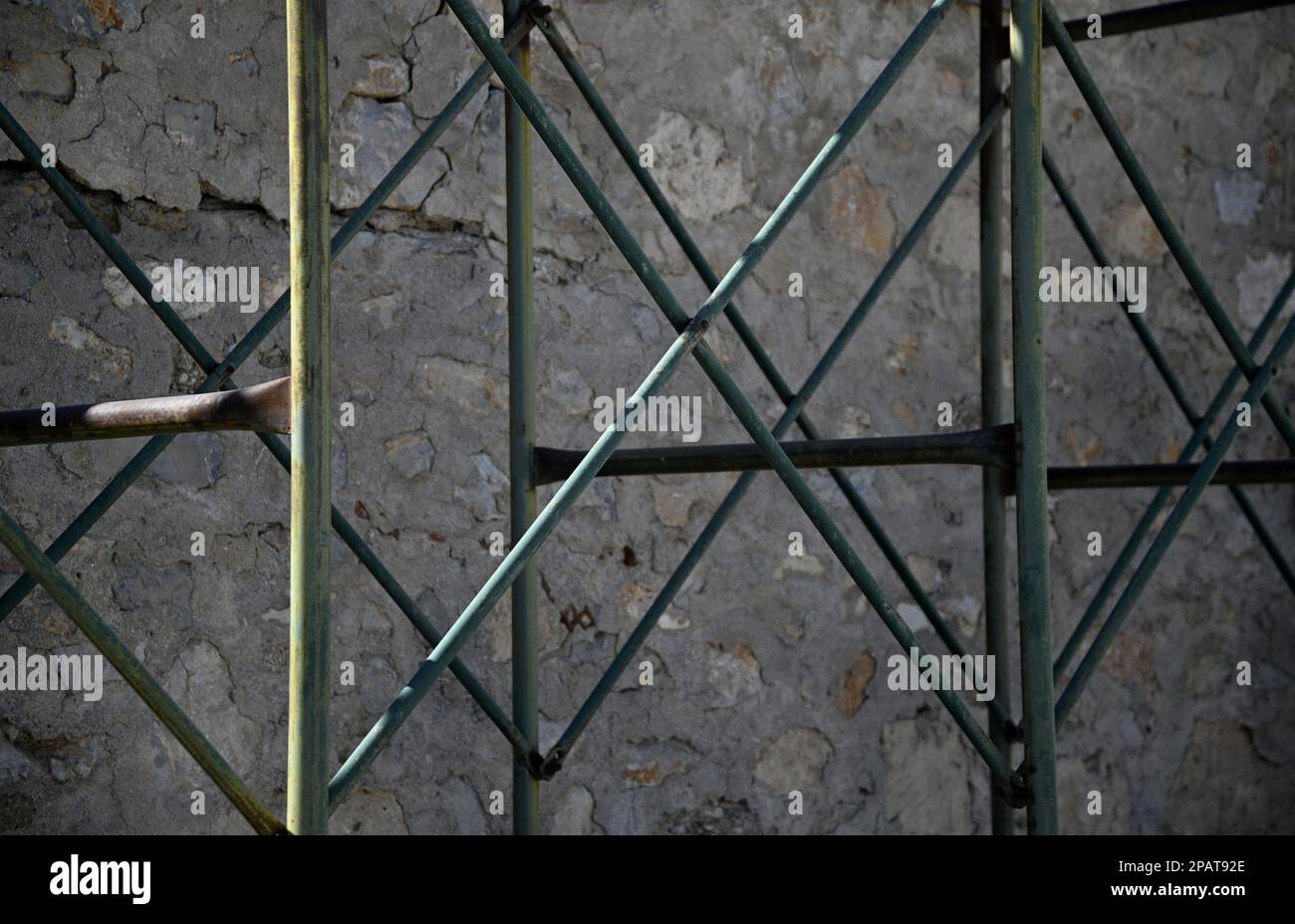 Green metal scaffold against a handcrafted stone wall Stock Photo - Alamy