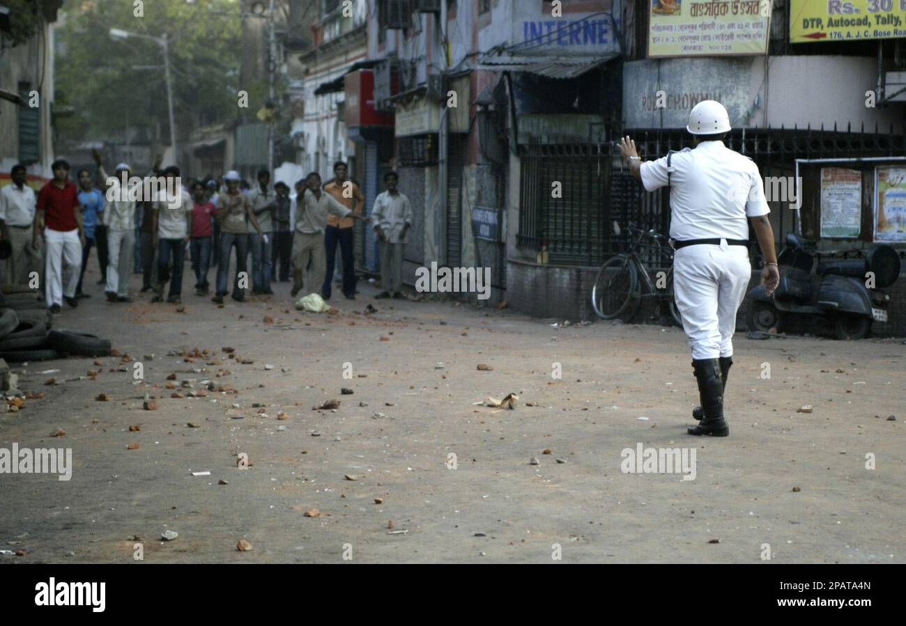 An Indian policeman appeals to a stone throwing mob in Calcutta, India ...
