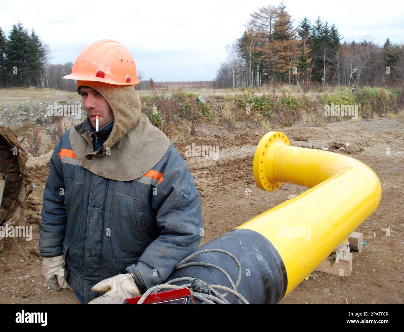 A worker takes a break during construction of oil and gas pipelines on ...