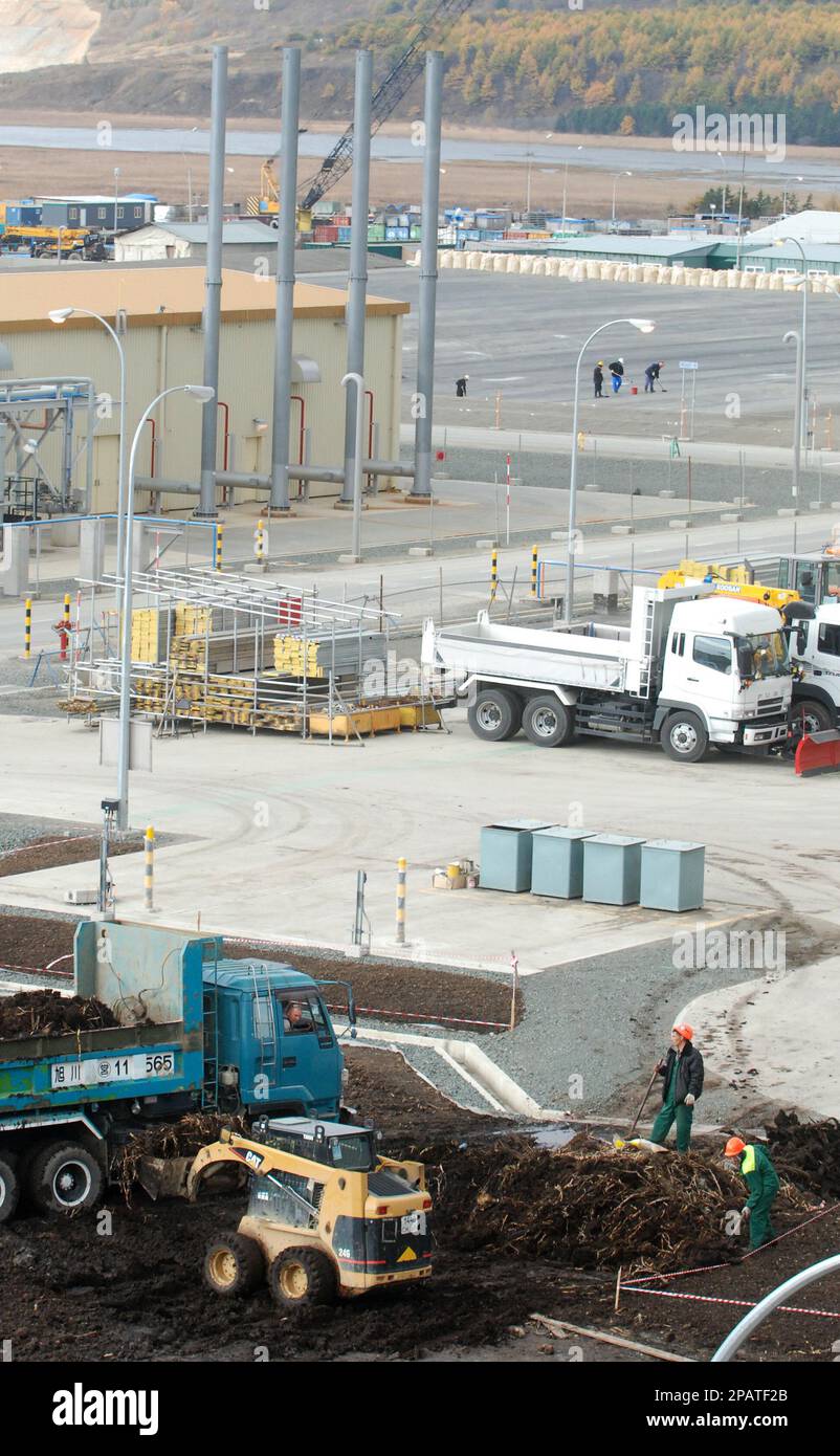 Workers clear ground at the construction of the terminus of oil and gas ...